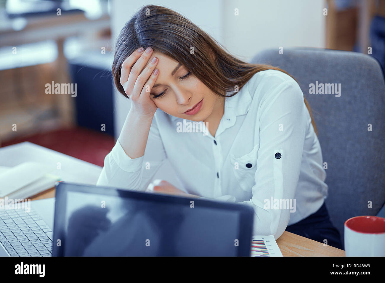 Tired woman in office Stock Photo - Alamy