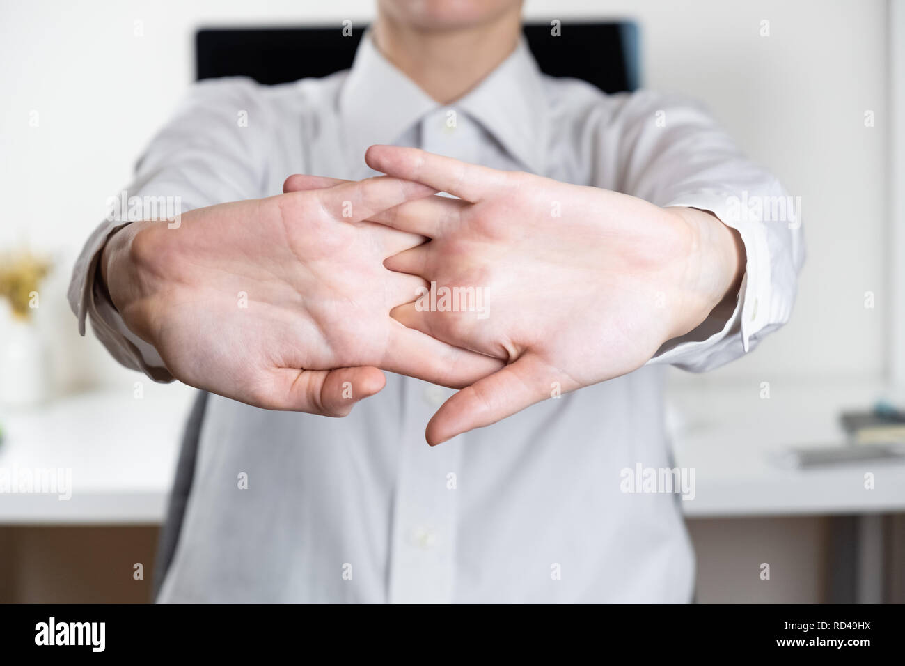Stretching arms in sparse office workplace. Hands of an employee in ...