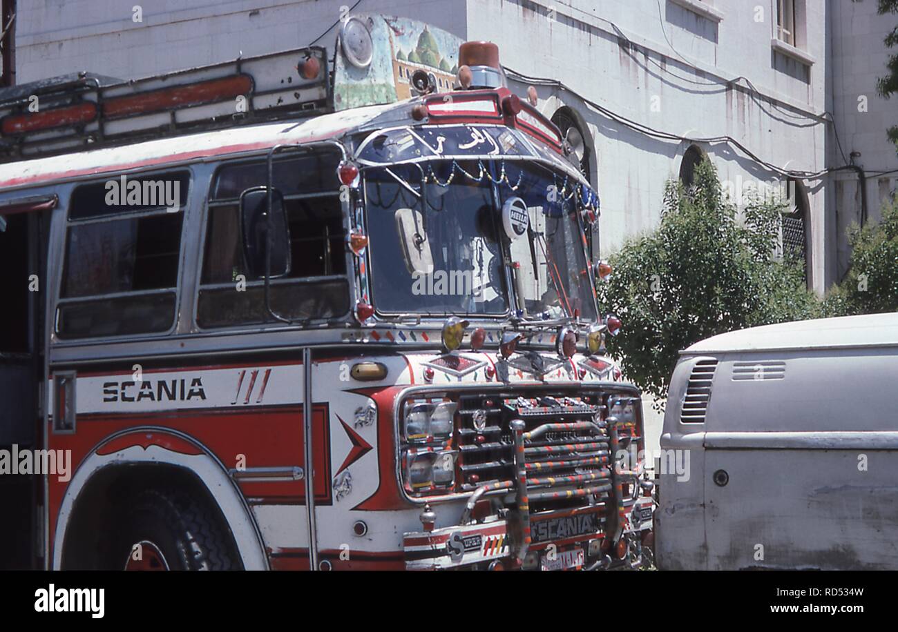 Detail view of a colorfully decorated Scania tour bus parked on a ...