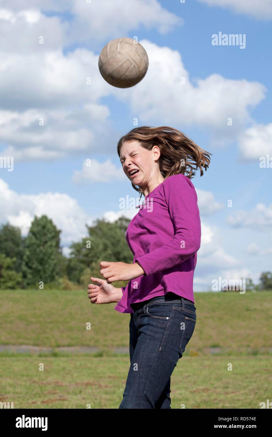 Girl playing football, heading ball Stock Photo - Alamy