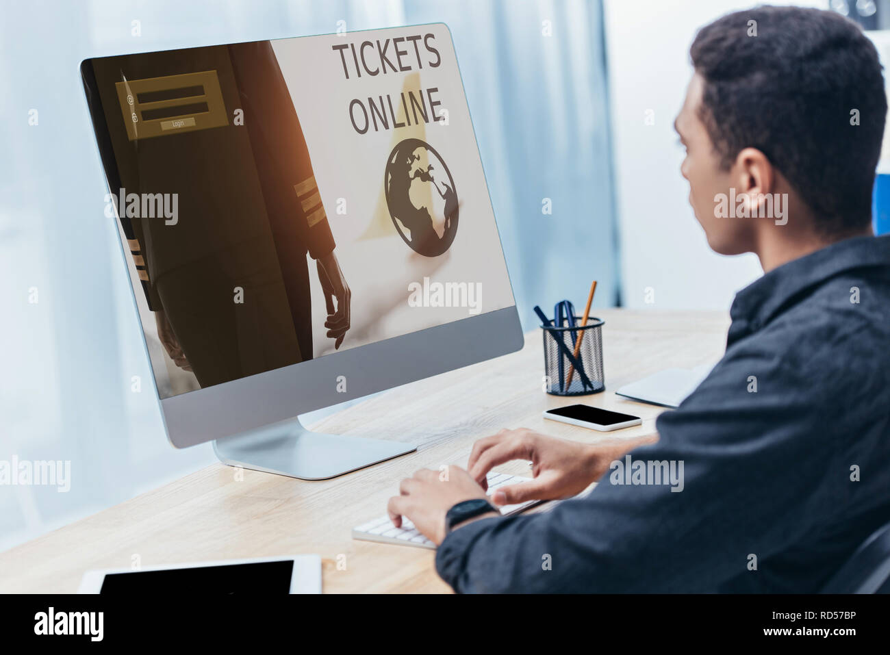 young businessman using desktop computer with tickets online website on ...