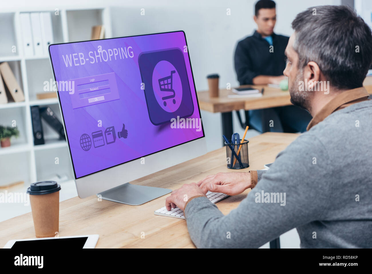 businessman using desktop computer with web shopping on screen in ...