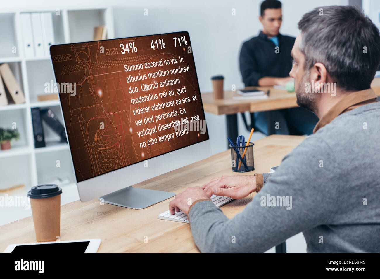 businessman using desktop computer with statistics on screen in office ...