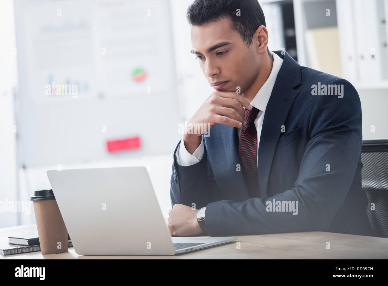 focused young businessman in suit working with laptop in office Stock ...