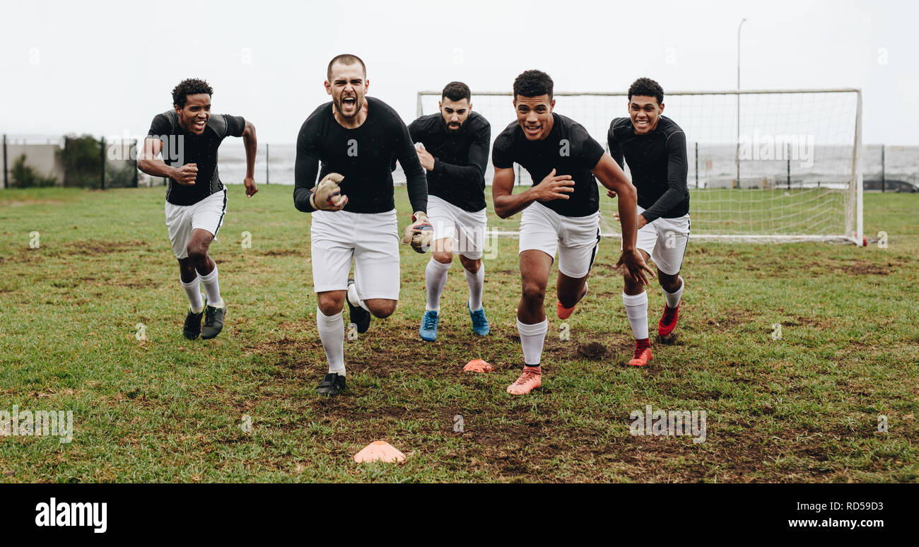 Soccer players running on field shouting in joy after winning the match ...