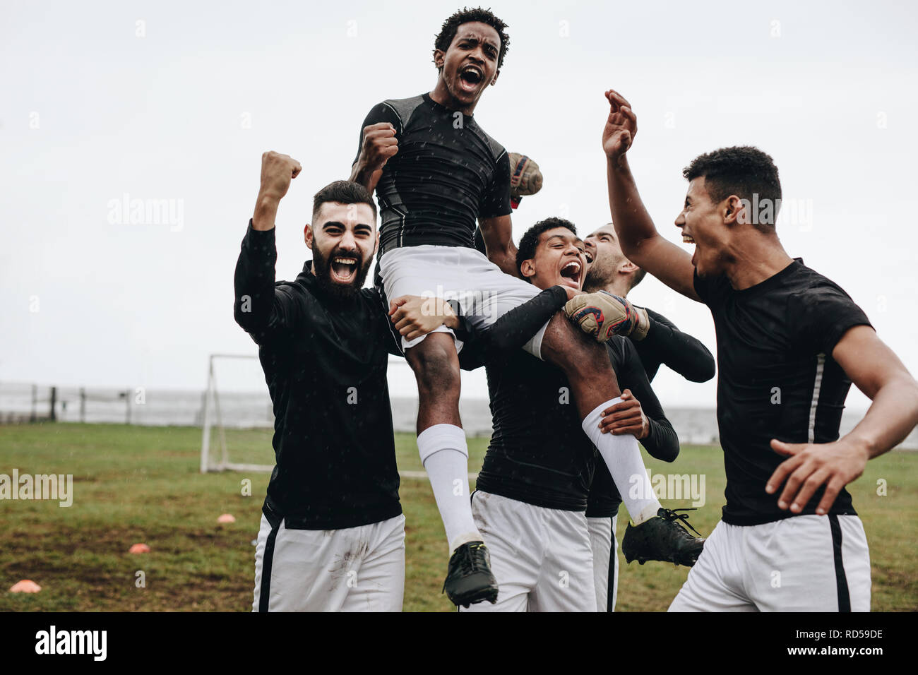 footballers shouting in joy and pumping their fists after a win ...