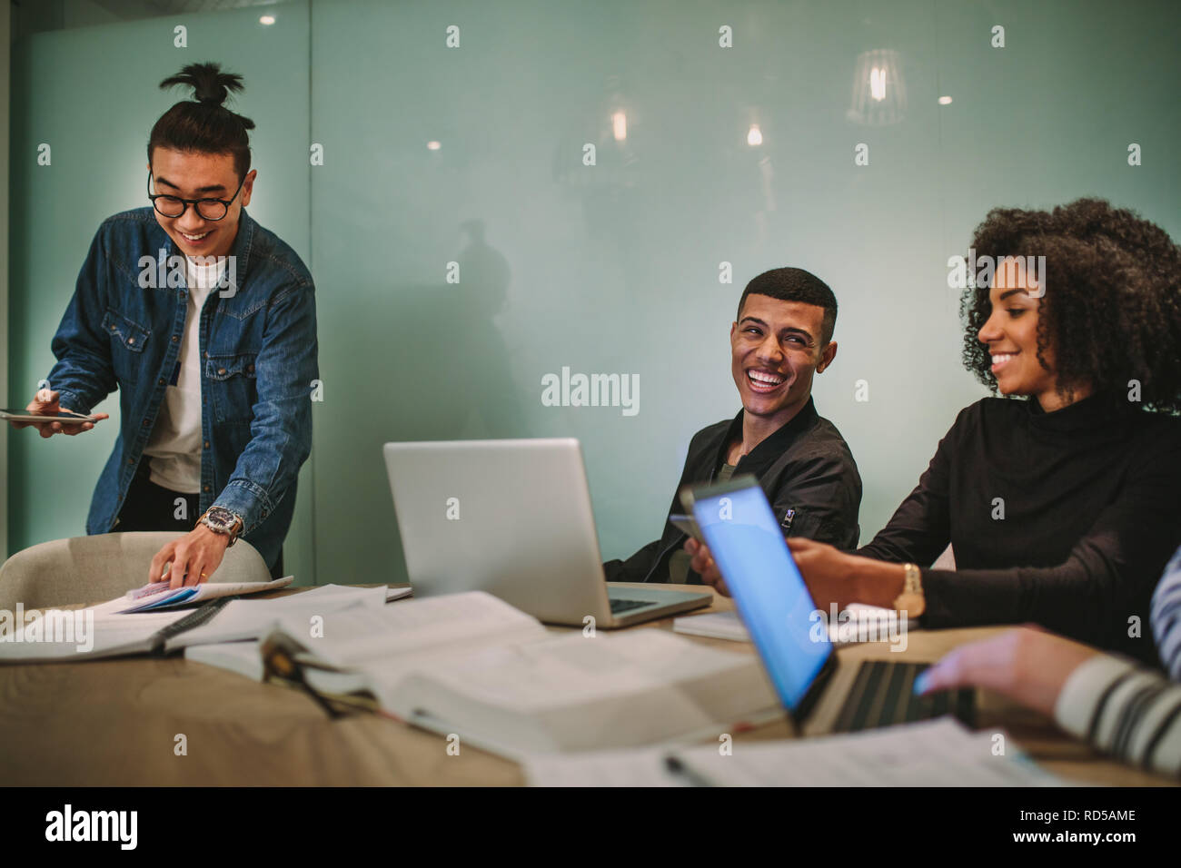 Group of multi-ethnic students sitting around table with books and ...