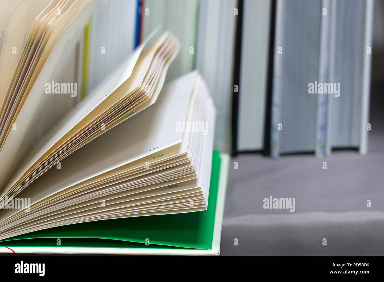 Open book, stack of hardback books on table. Top view Stock Photo - Alamy