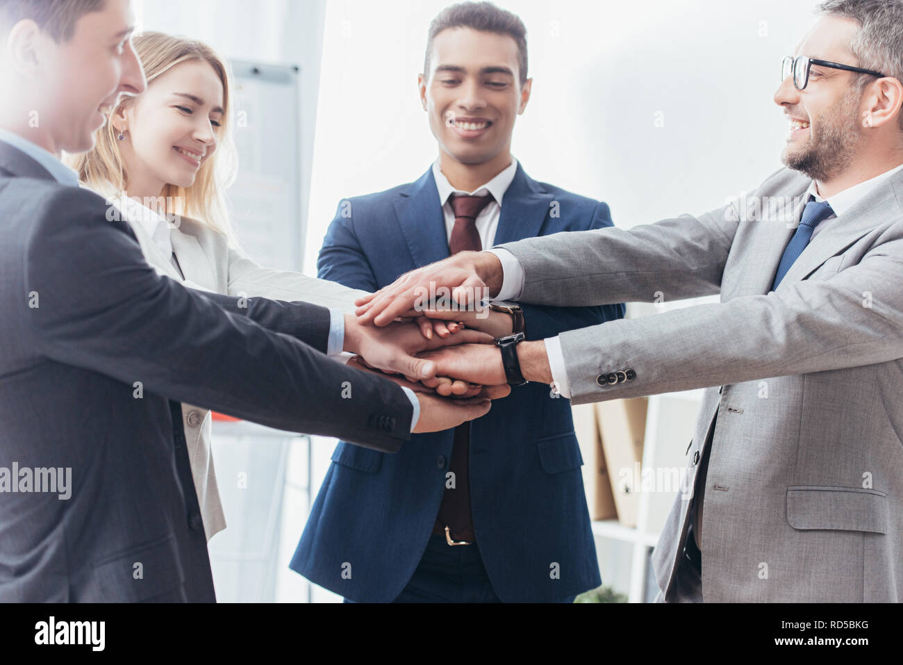 happy professional business team stacking hands in office Stock Photo ...
