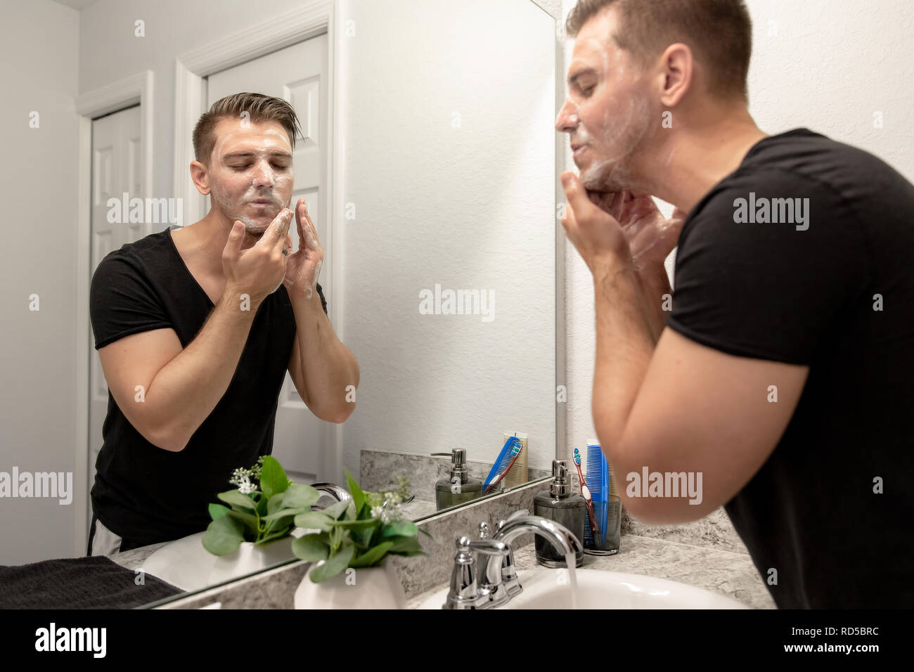 Good Looking Young Man Washing Hands and Face in Home Bathroom Mirror ...