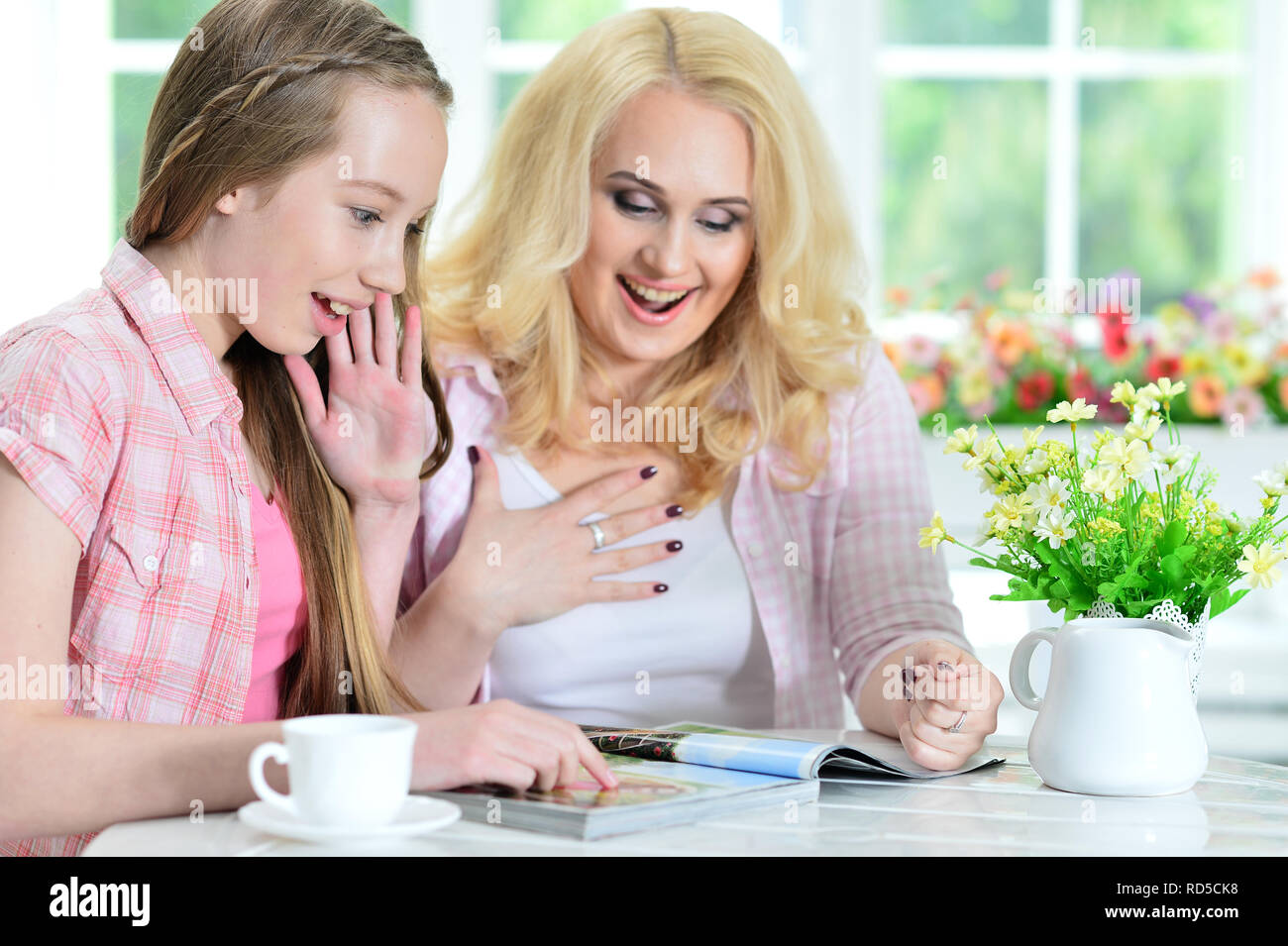 Portrait of mother and daughter reading magazine Stock Photo - Alamy