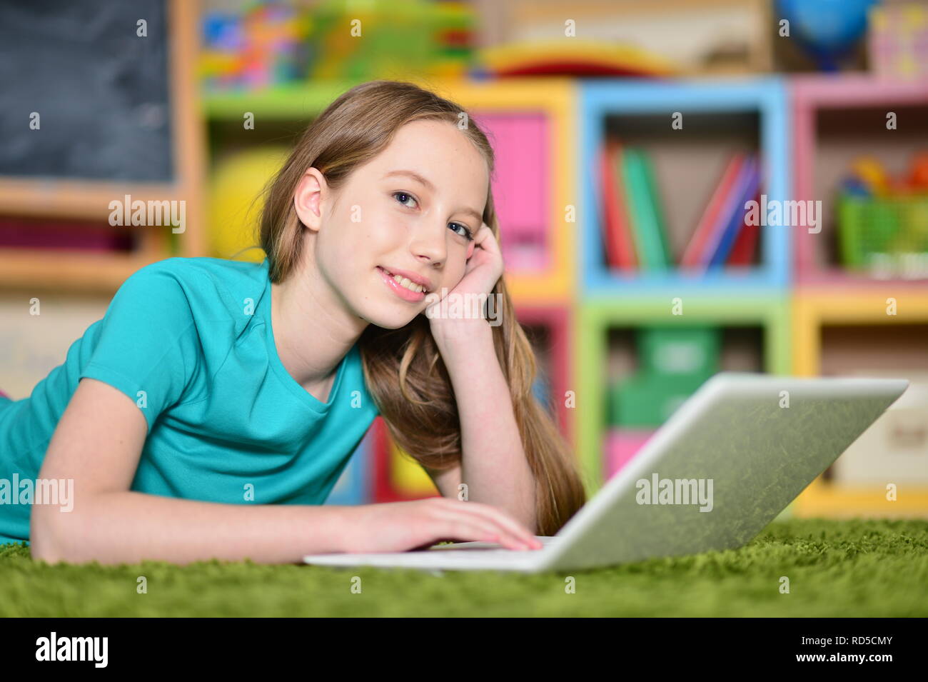 Portrait of cute girl with laptop computer on floor Stock Photo - Alamy