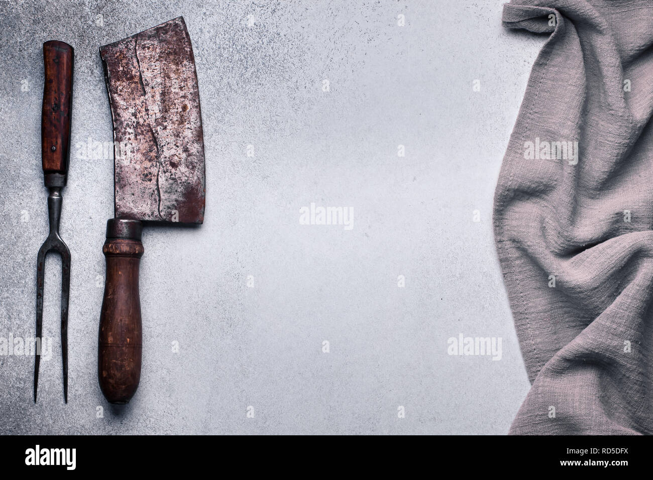 Meat cleaver and fork on concrete background Stock Photo - Alamy