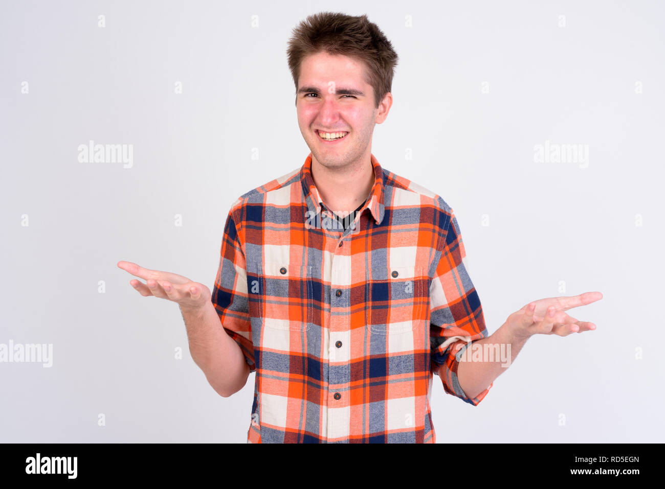 Happy young handsome man shrugging shoulders against white background ...