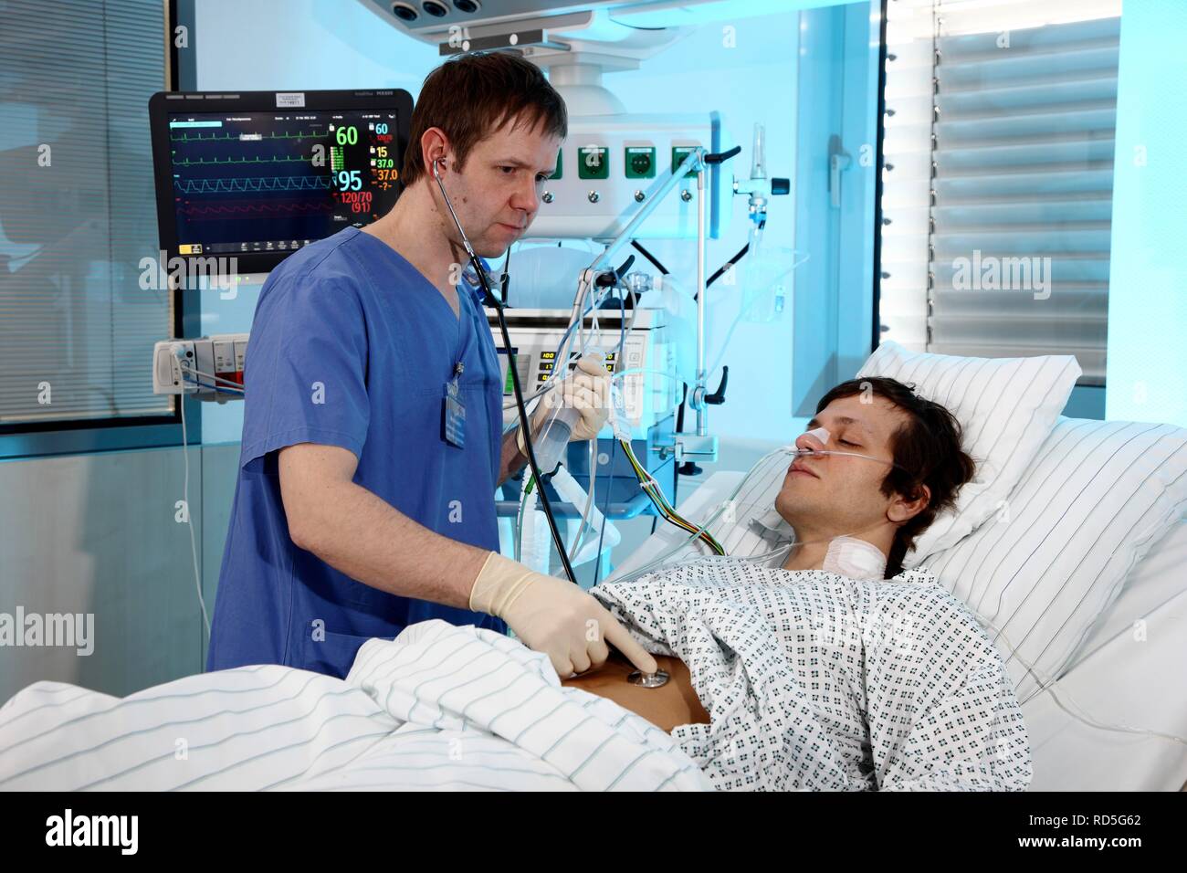 Male intensive care nurse looking after a patient lying in a special ...