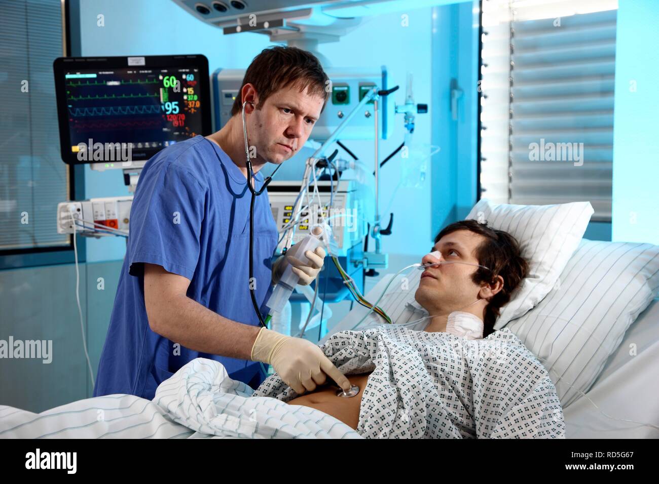 Male intensive care nurse looking after a patient lying in a special ...