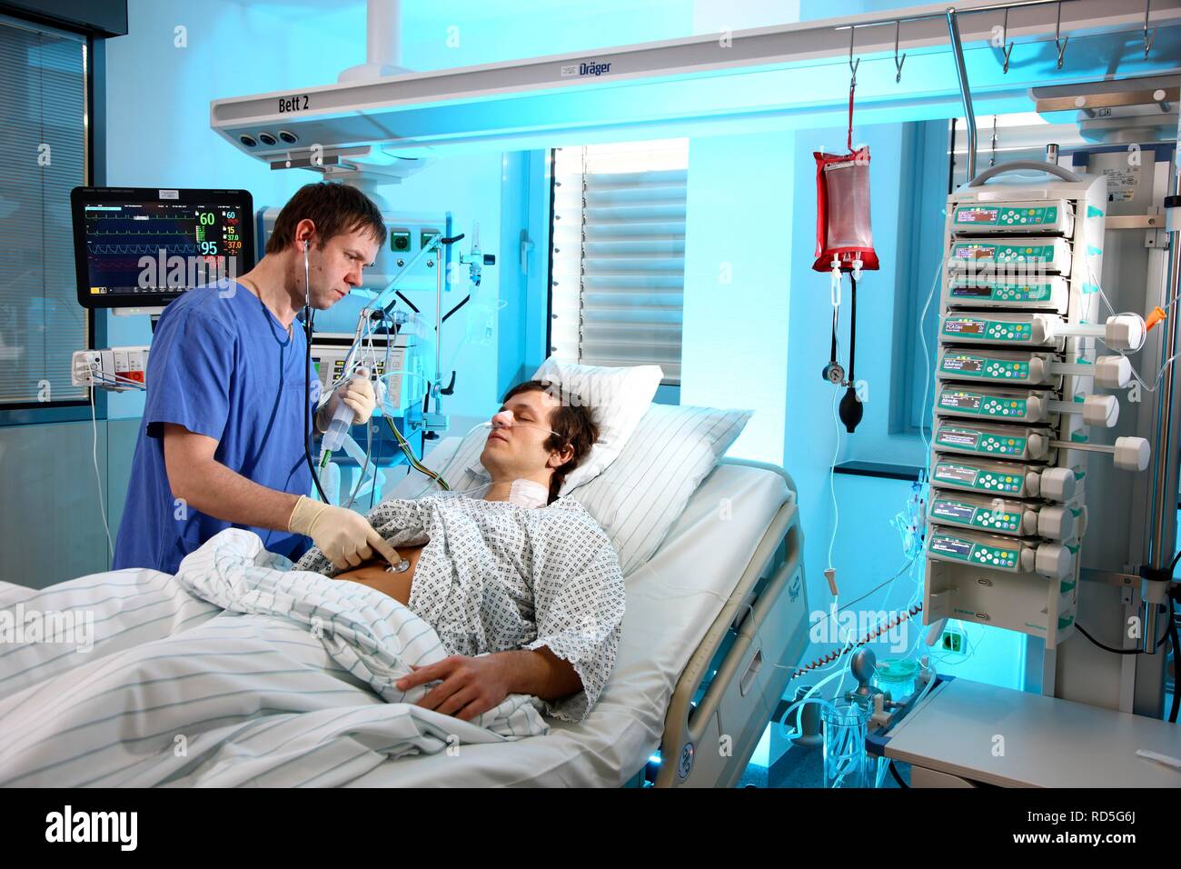 Male intensive care nurse looking after a patient lying in a special ...