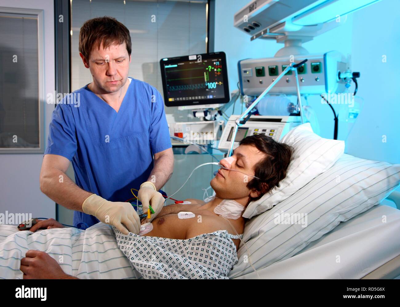 Male intensive care nurse looking after a patient lying in a special ...