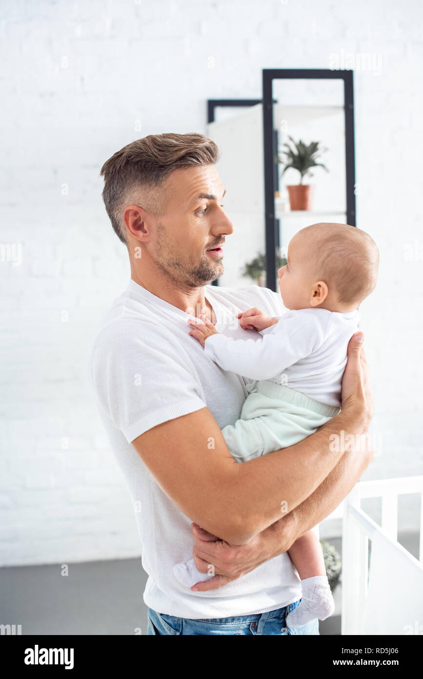 father looking surprised at baby daughter at home Stock Photo - Alamy