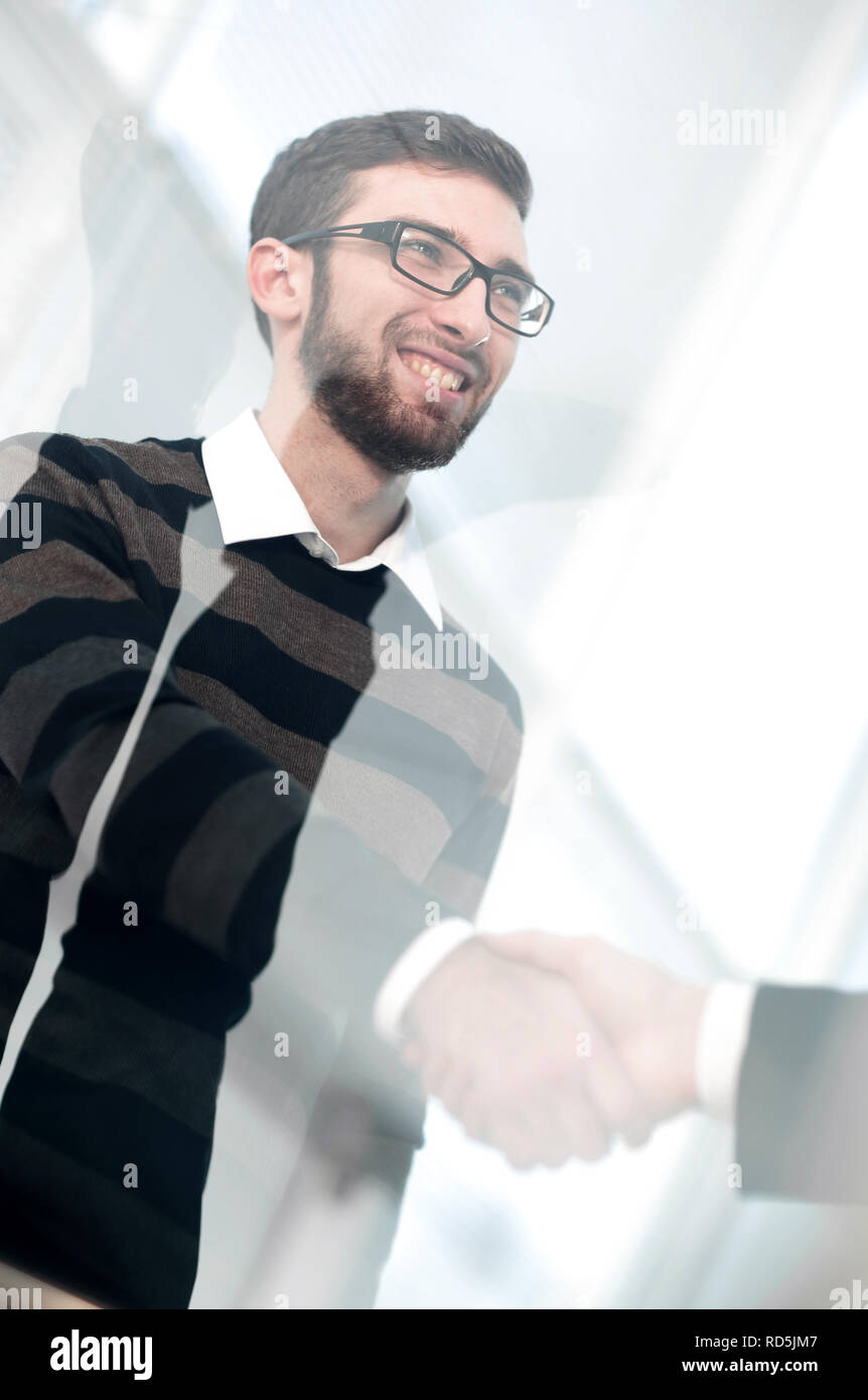 from behind the glass.handshake business people Stock Photo - Alamy
