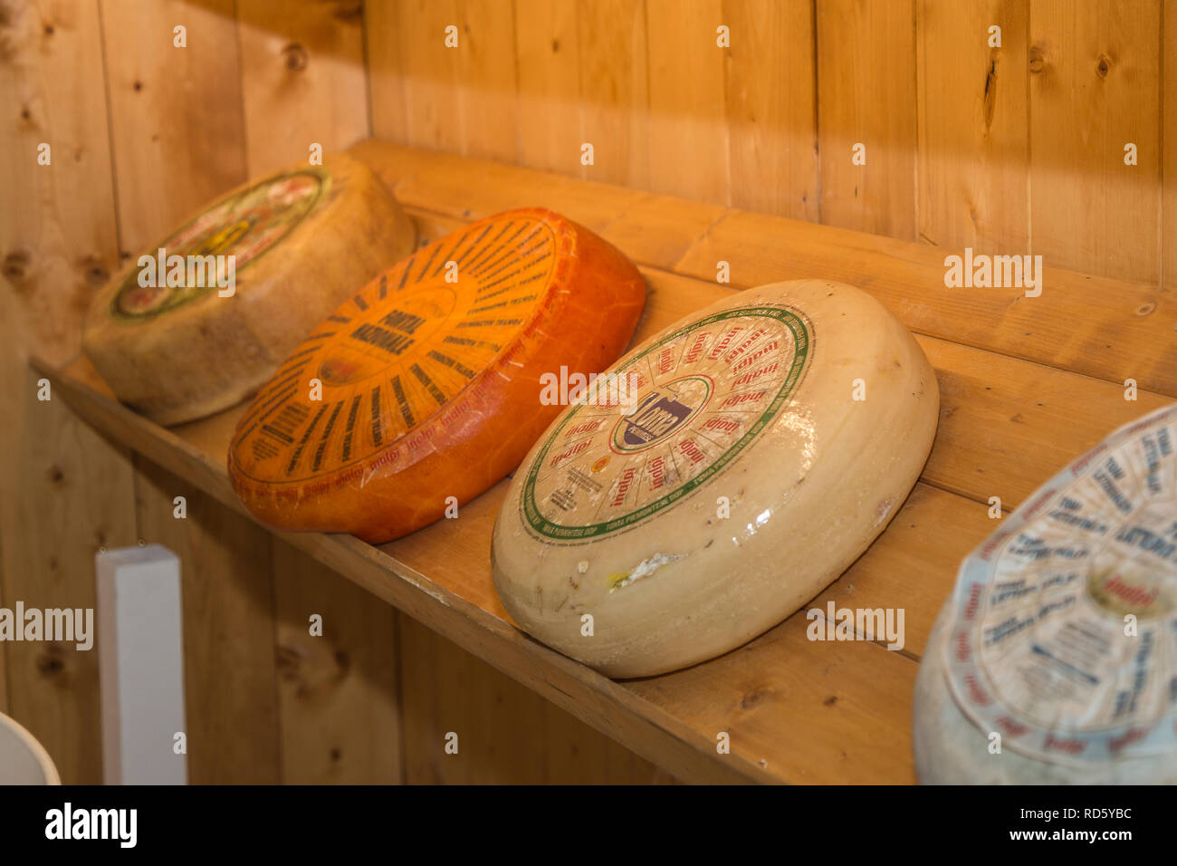Round Cheese Shapes Displayed on a Wooden Shelf of a Store Stock Photo ...