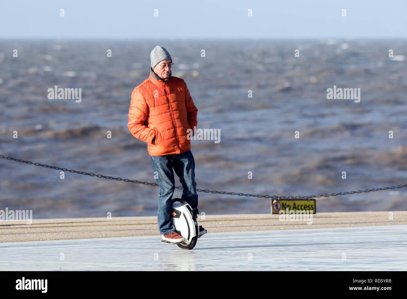 A man rides his self balancing unicycle gyro scooter along the ...