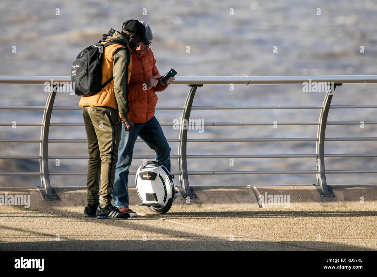 A man rides his self balancing unicycle gyro scooter along the ...