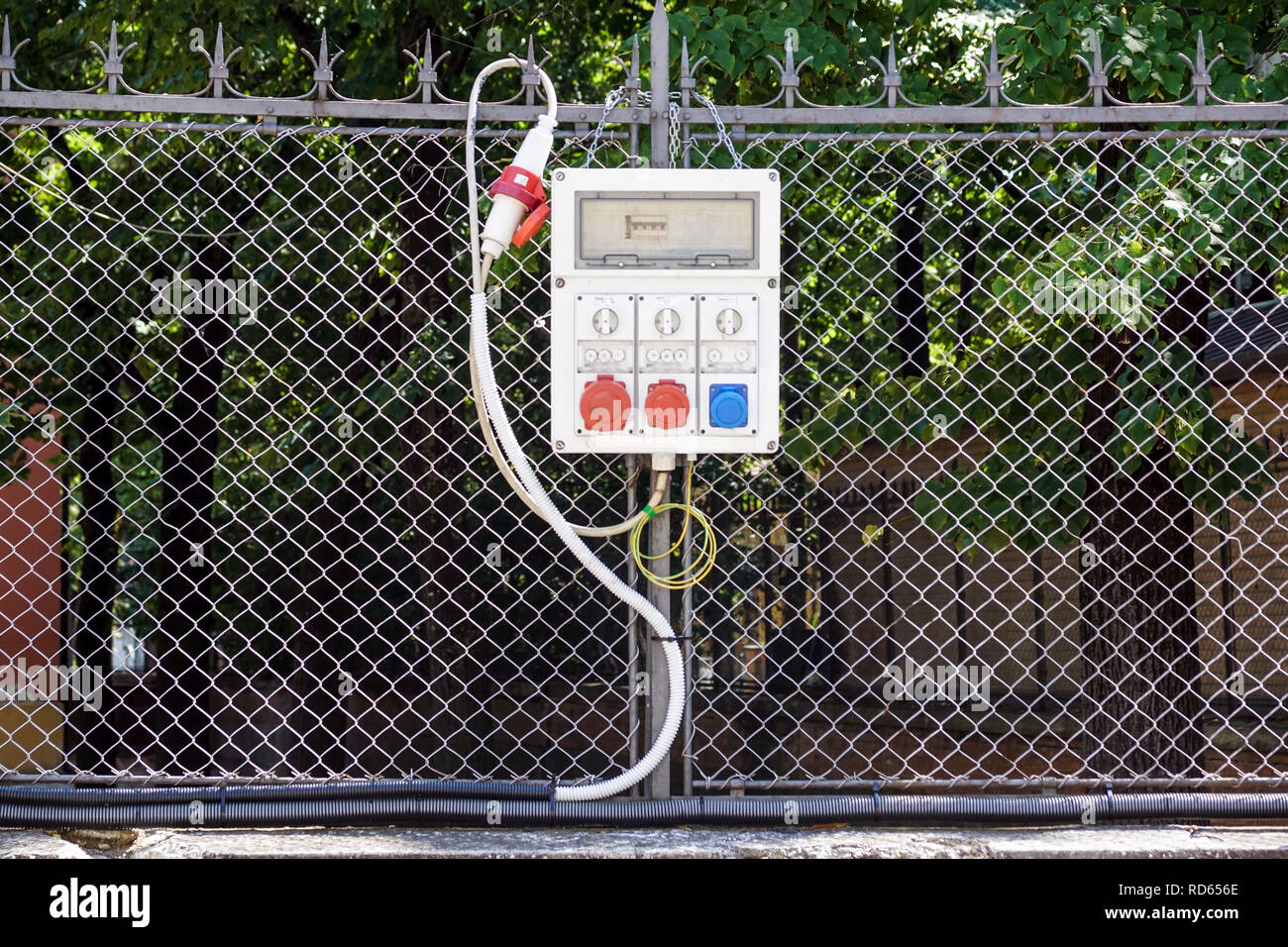 Old black electrical outlet with external wiring against the background ...
