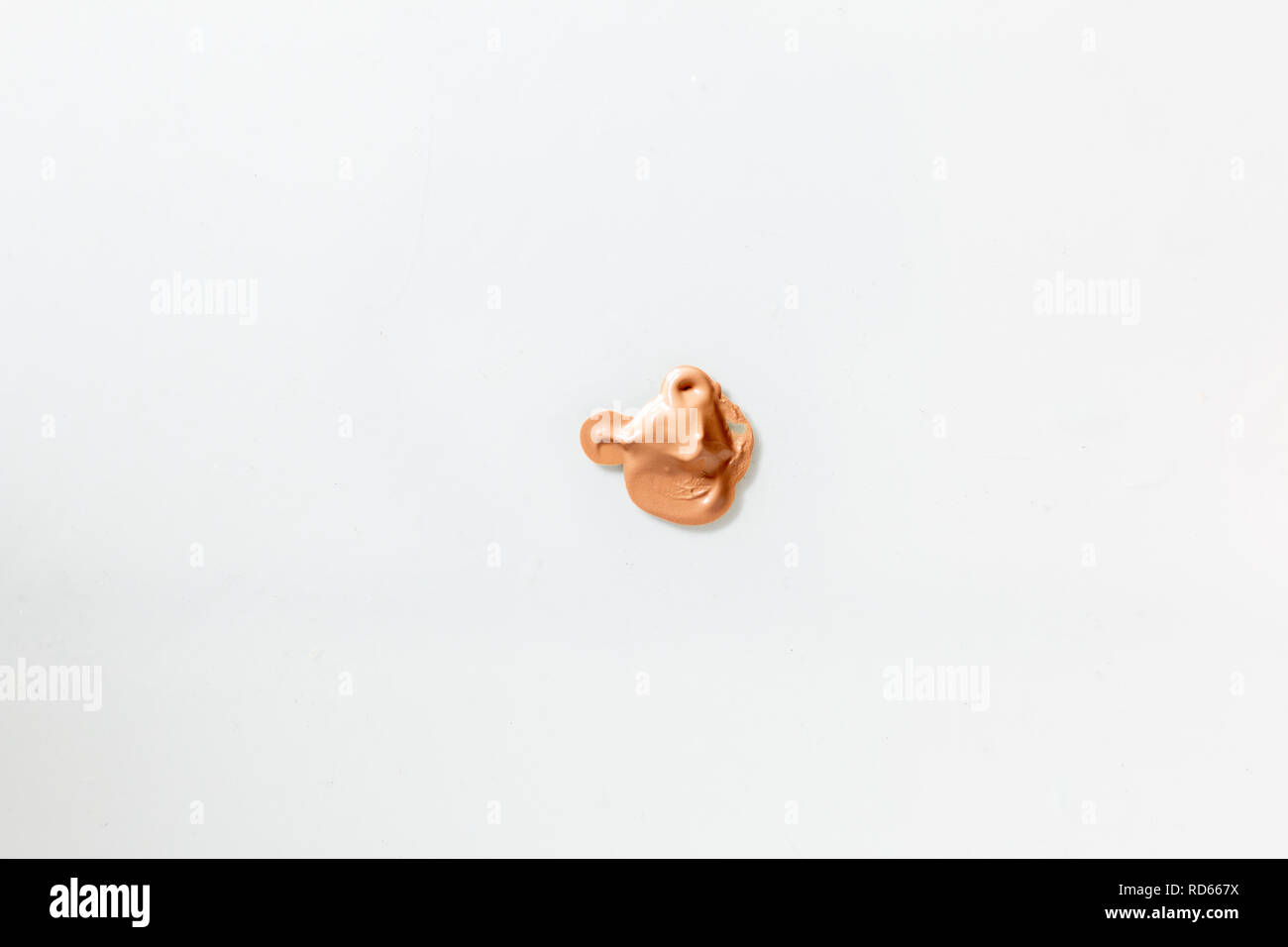 small beige blob of makeup in the centre of a white background Stock ...