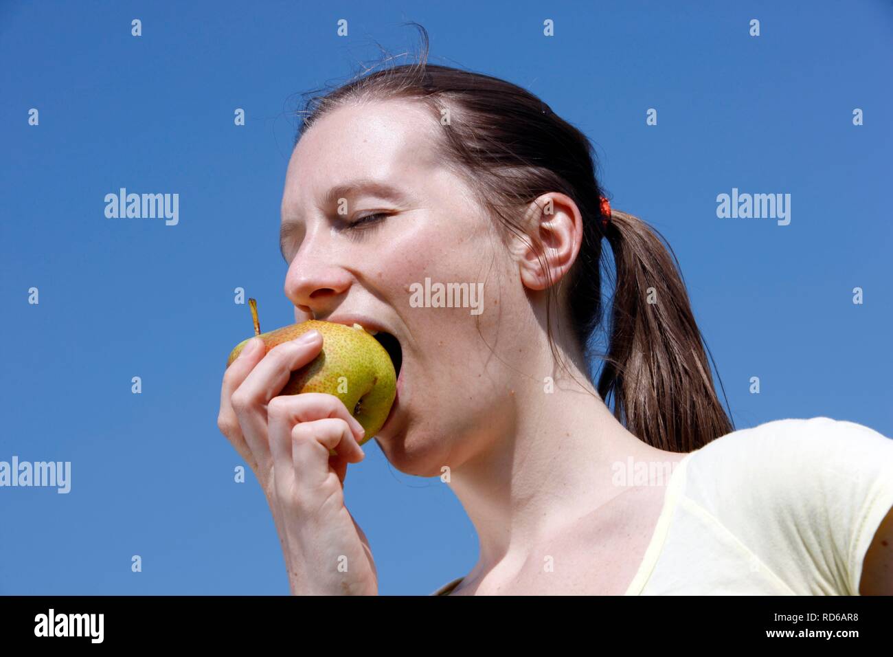Young woman, 25-30 years, eating an apple after exercise Stock Photo ...