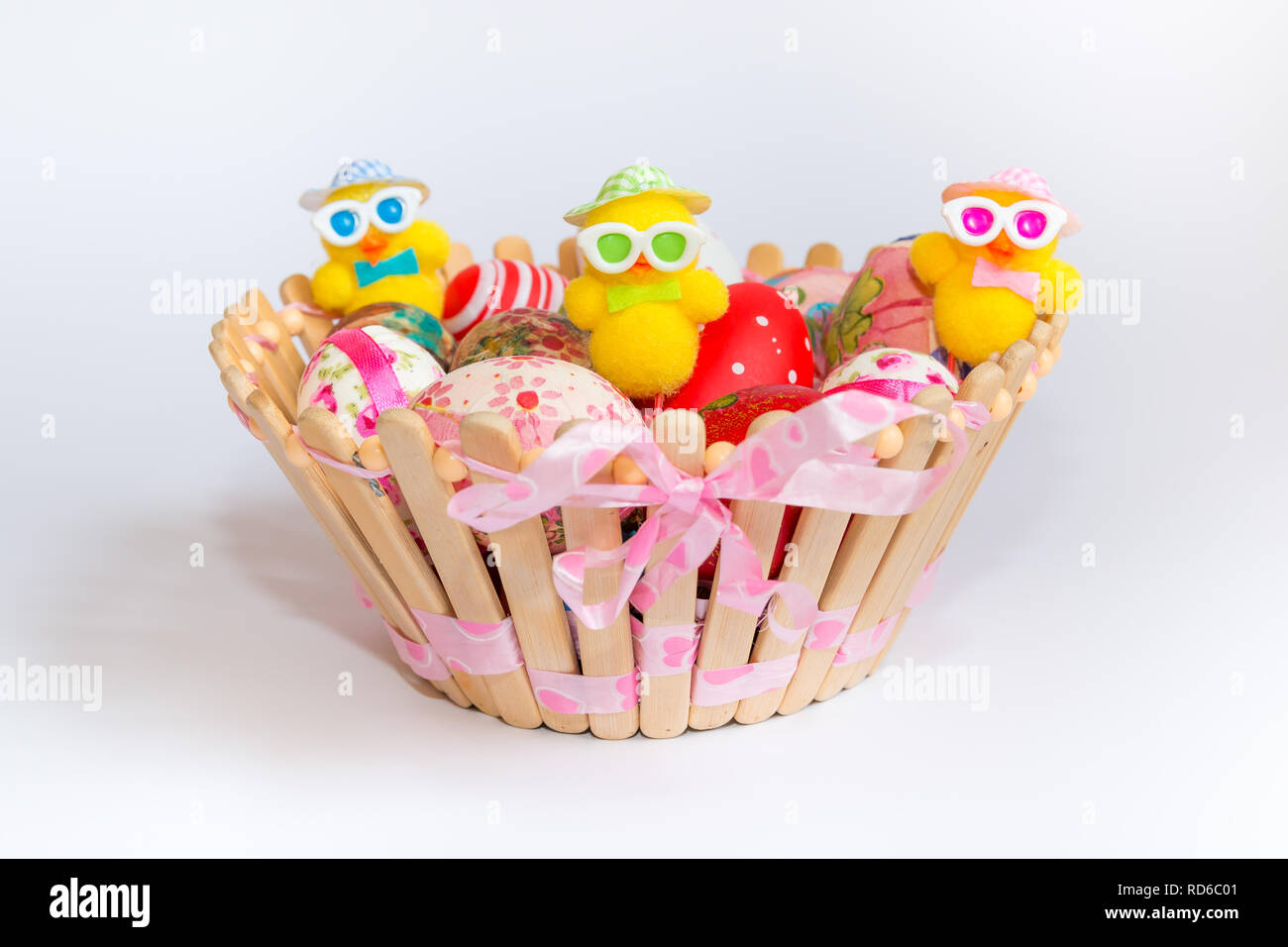 Easter decoration with colorful eggs and funny chicks in wooden basket ...