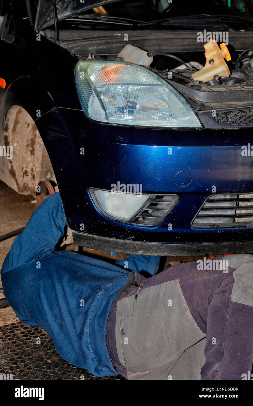 Mechanic lying working under car hi-res stock photography and images ...