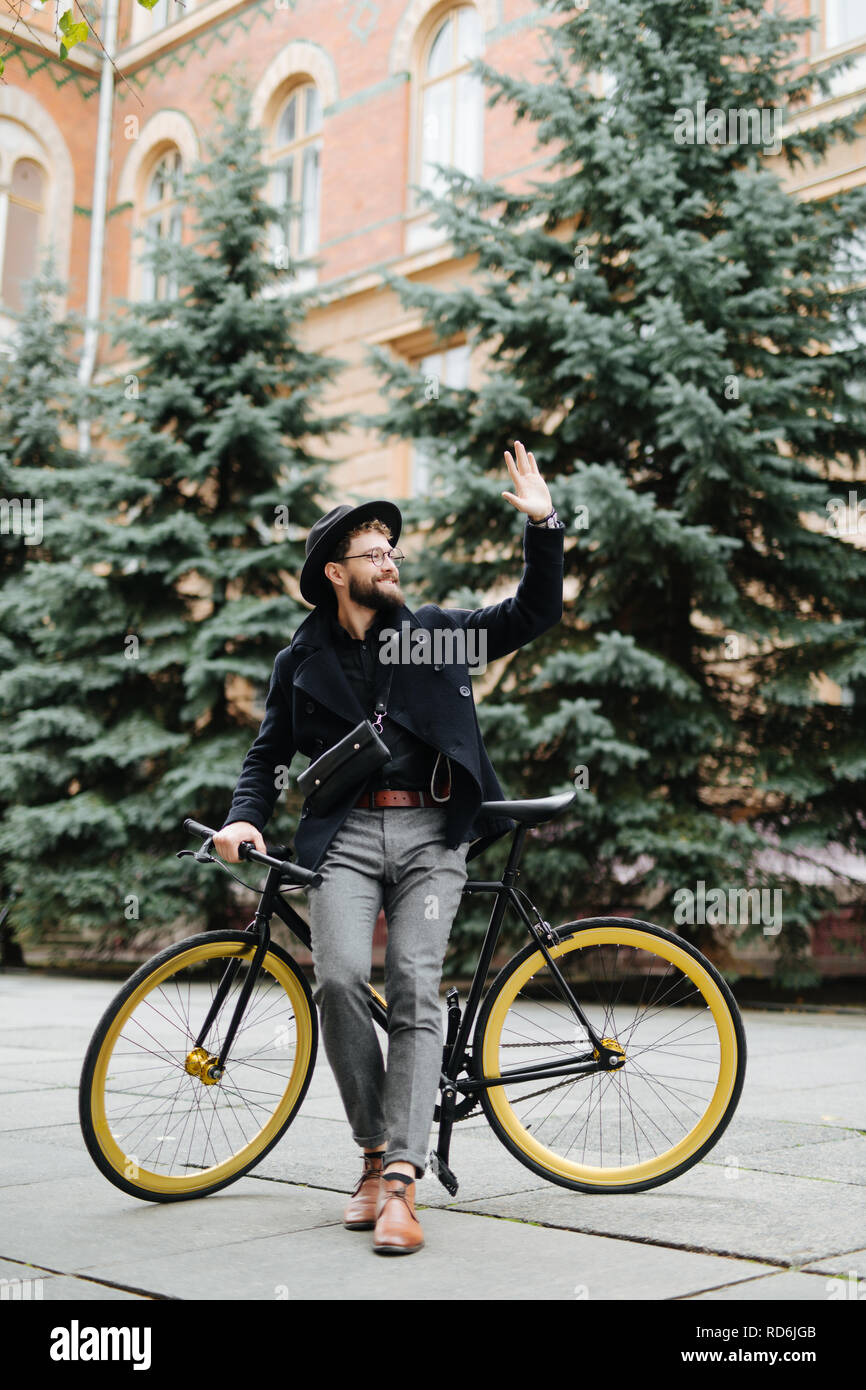 Stylish handsome hipster man riding bicycle and waving Hello Stock ...