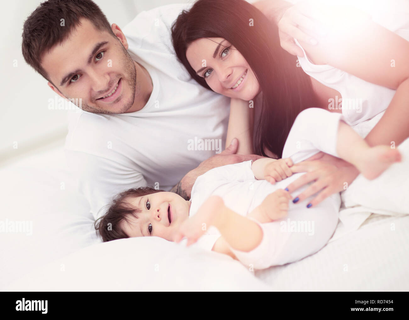 Happy young family with one child having fun together Stock Photo - Alamy