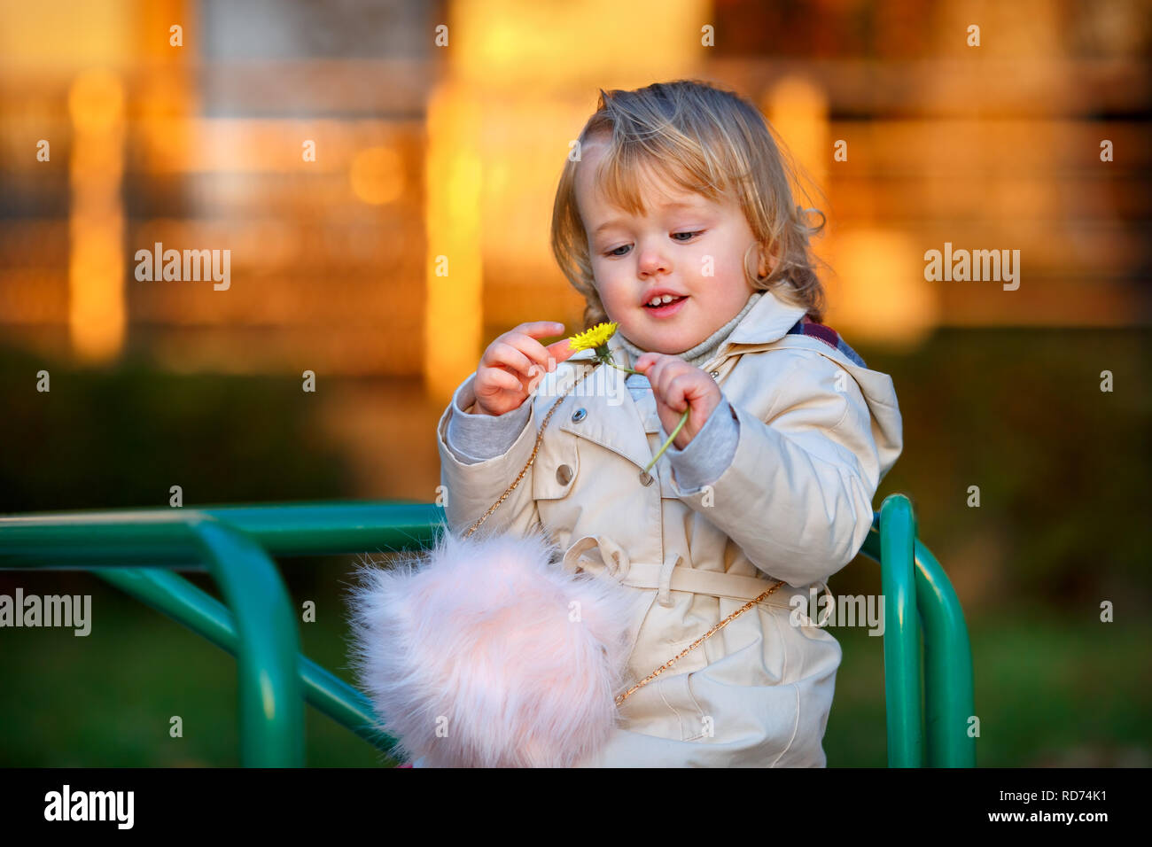 Portrait of sweet blond little baby girl in trench coat and faux fur ...