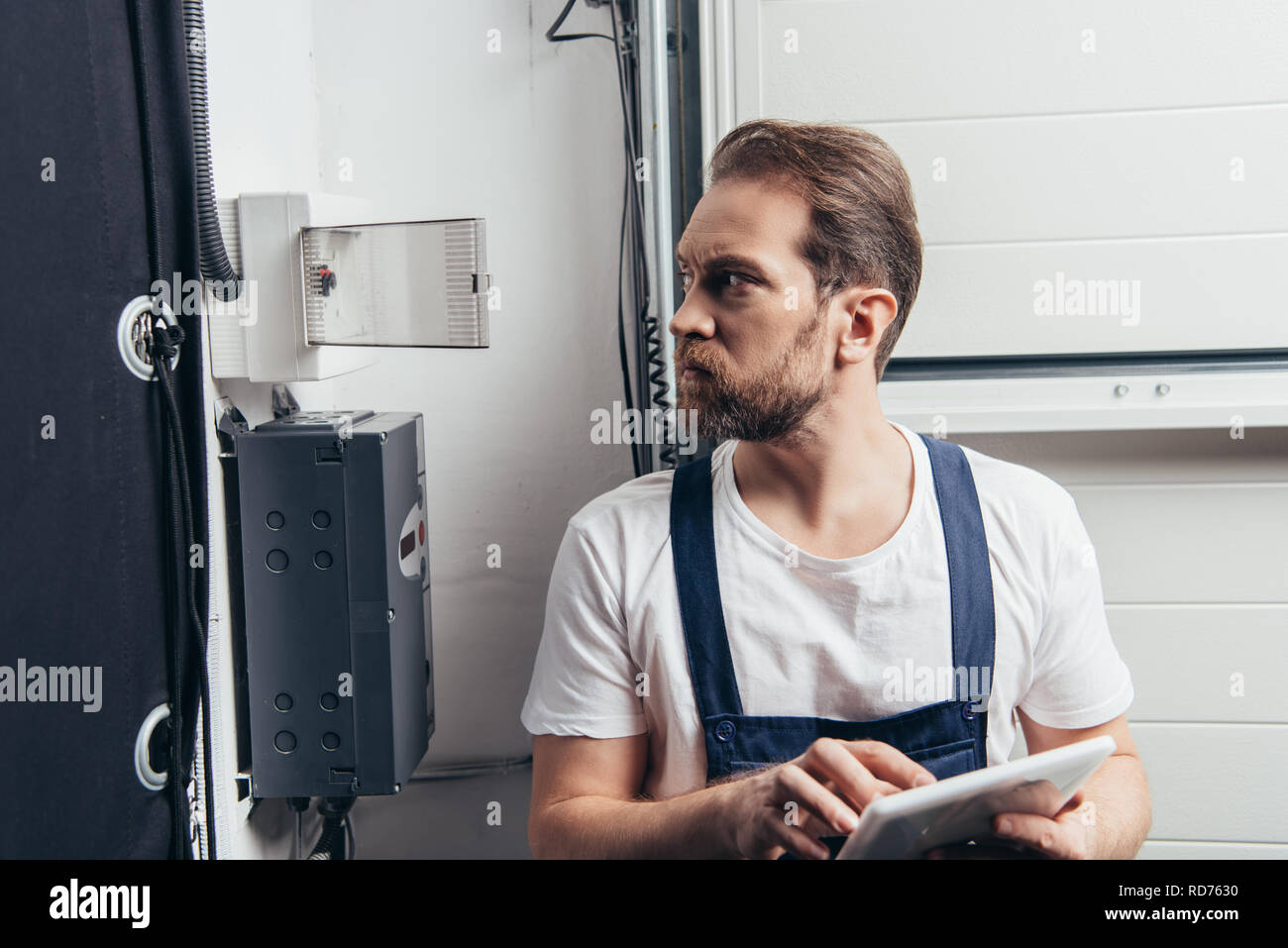 adult male repairman with digital tablet checking electrical box Stock ...