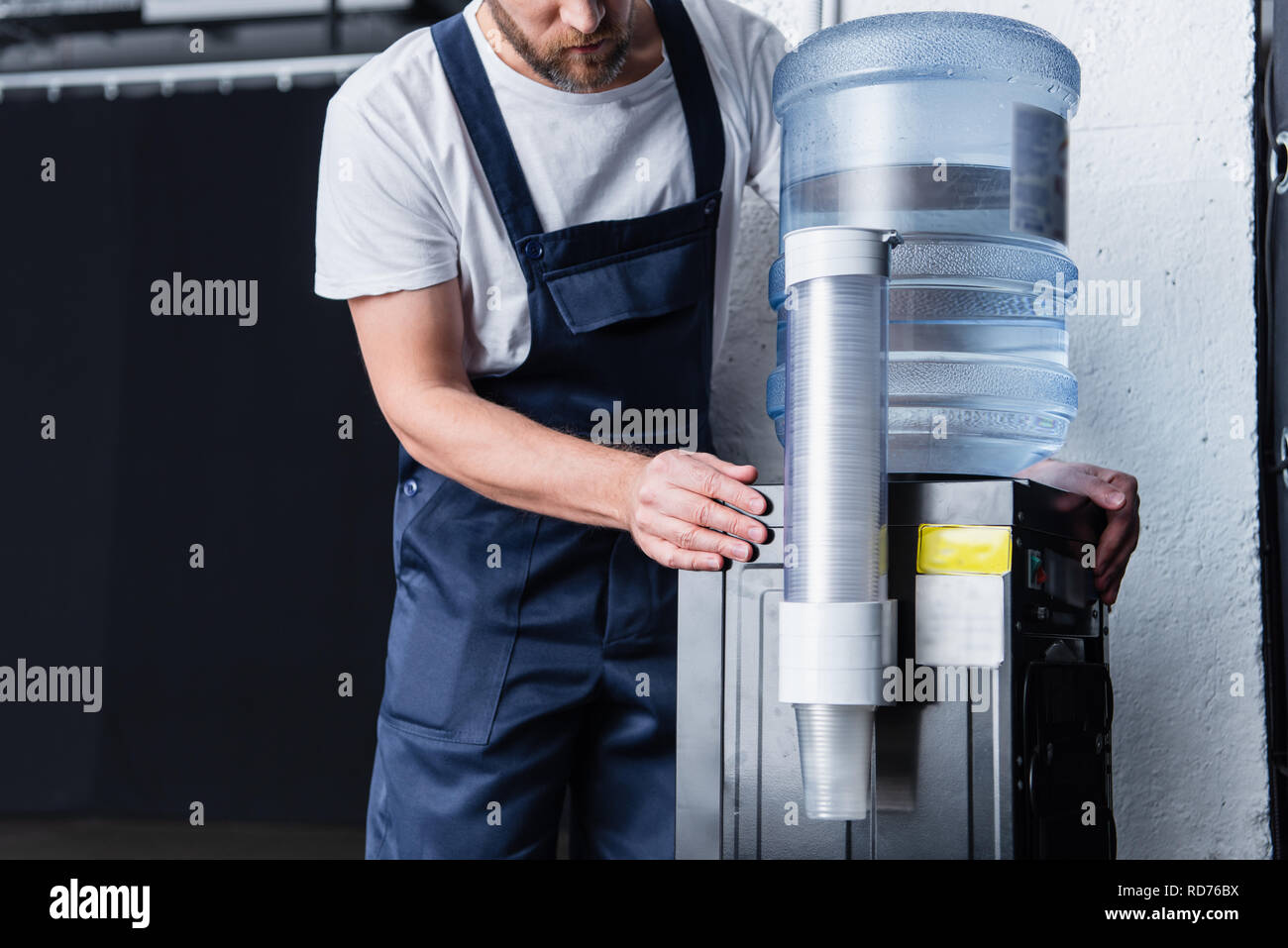 partial view of handyman checking broken water cooler Stock Photo - Alamy