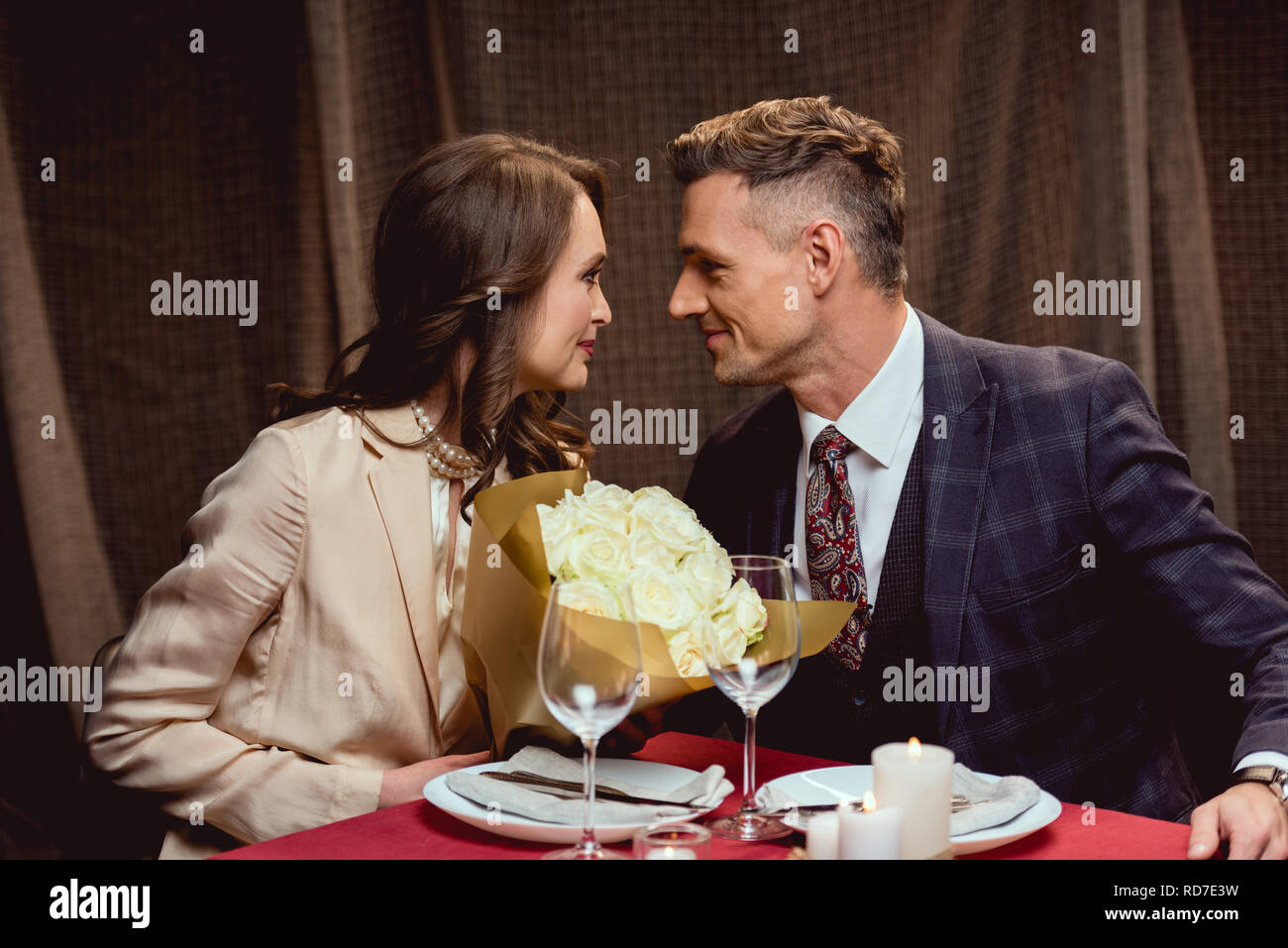 Romantic couple sitting table bouquet hi-res stock photography and ...