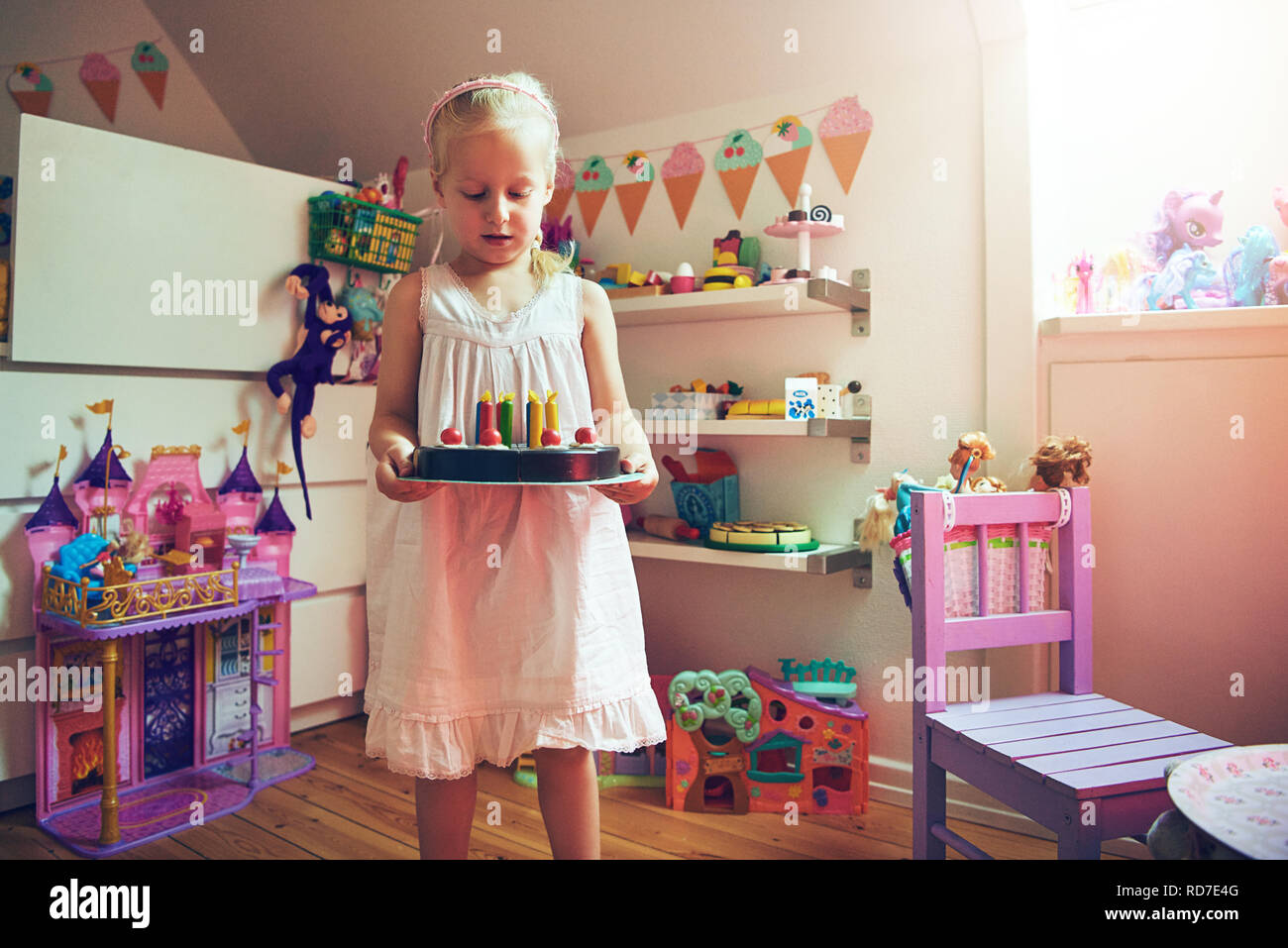 Cute little kid holding plastic toy cake. Horizontal indoors shot Stock ...