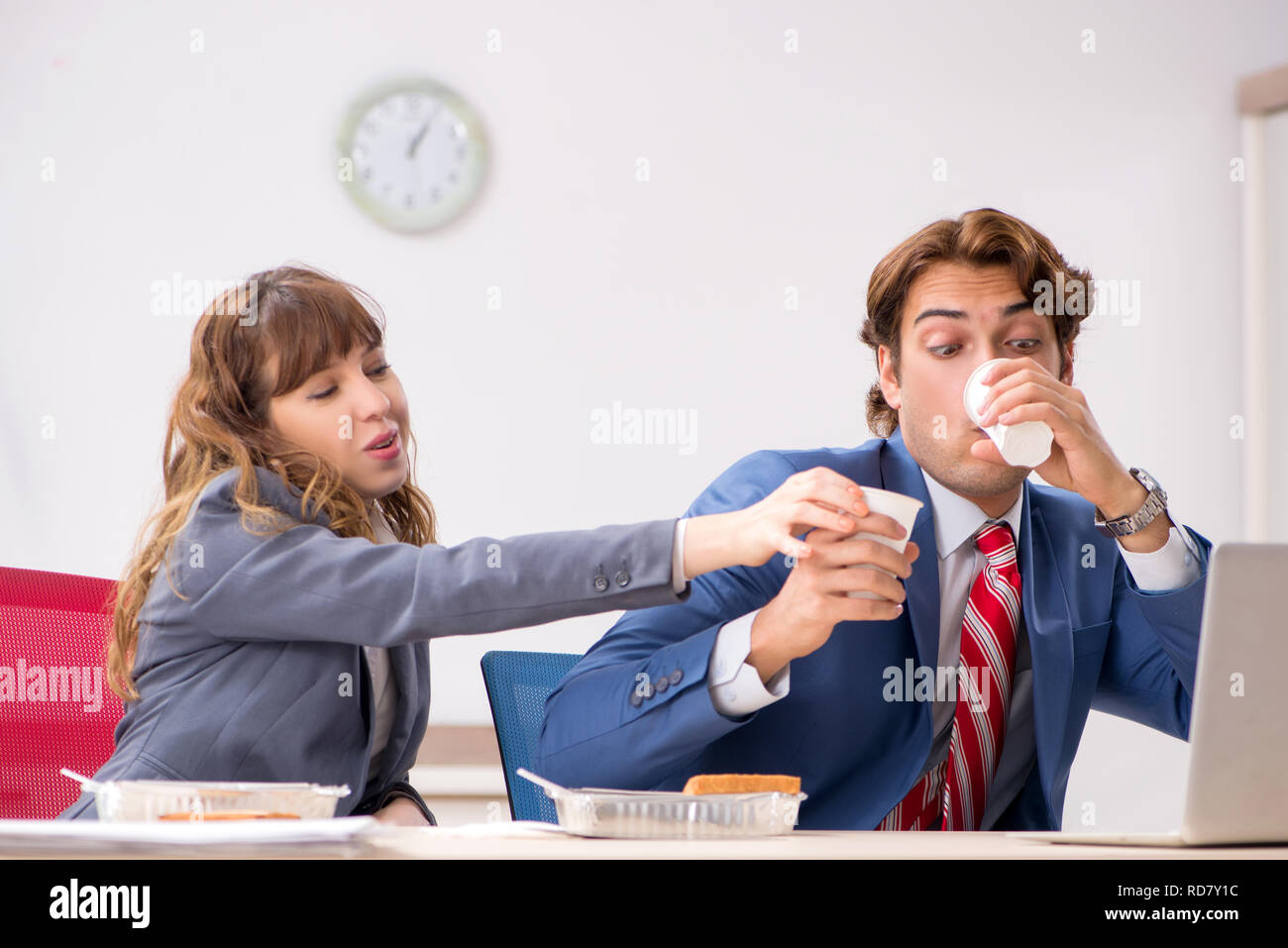 Two colleagues having lunch break at workplace Stock Photo - Alamy