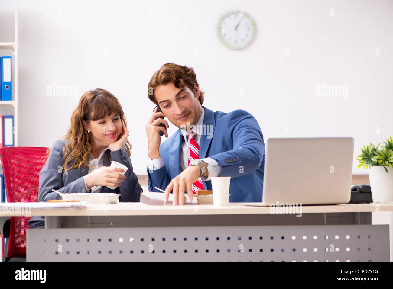 Two colleagues having lunch break at workplace Stock Photo - Alamy