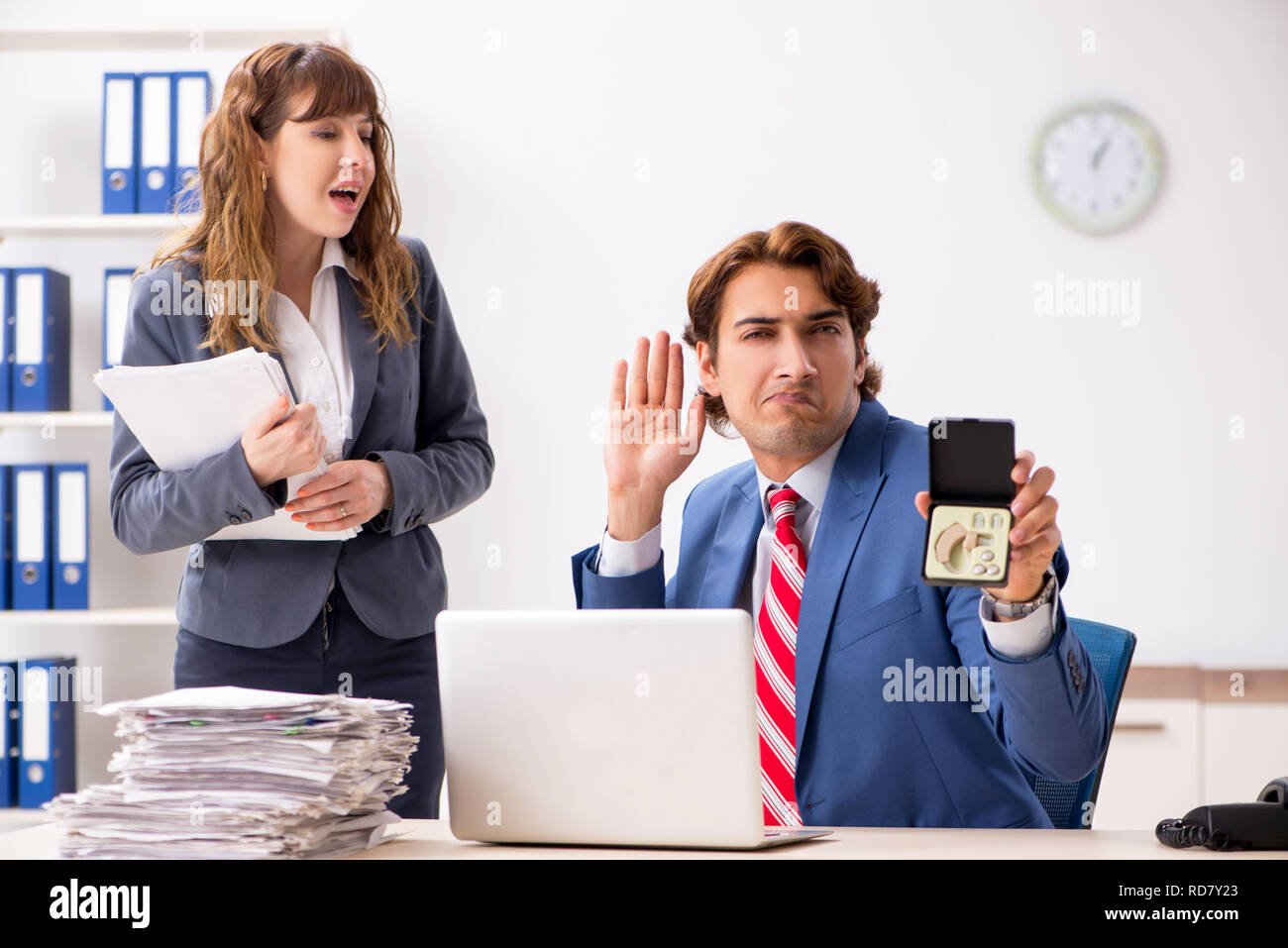 Deaf employee using hearing aid talking to boss Stock Photo - Alamy