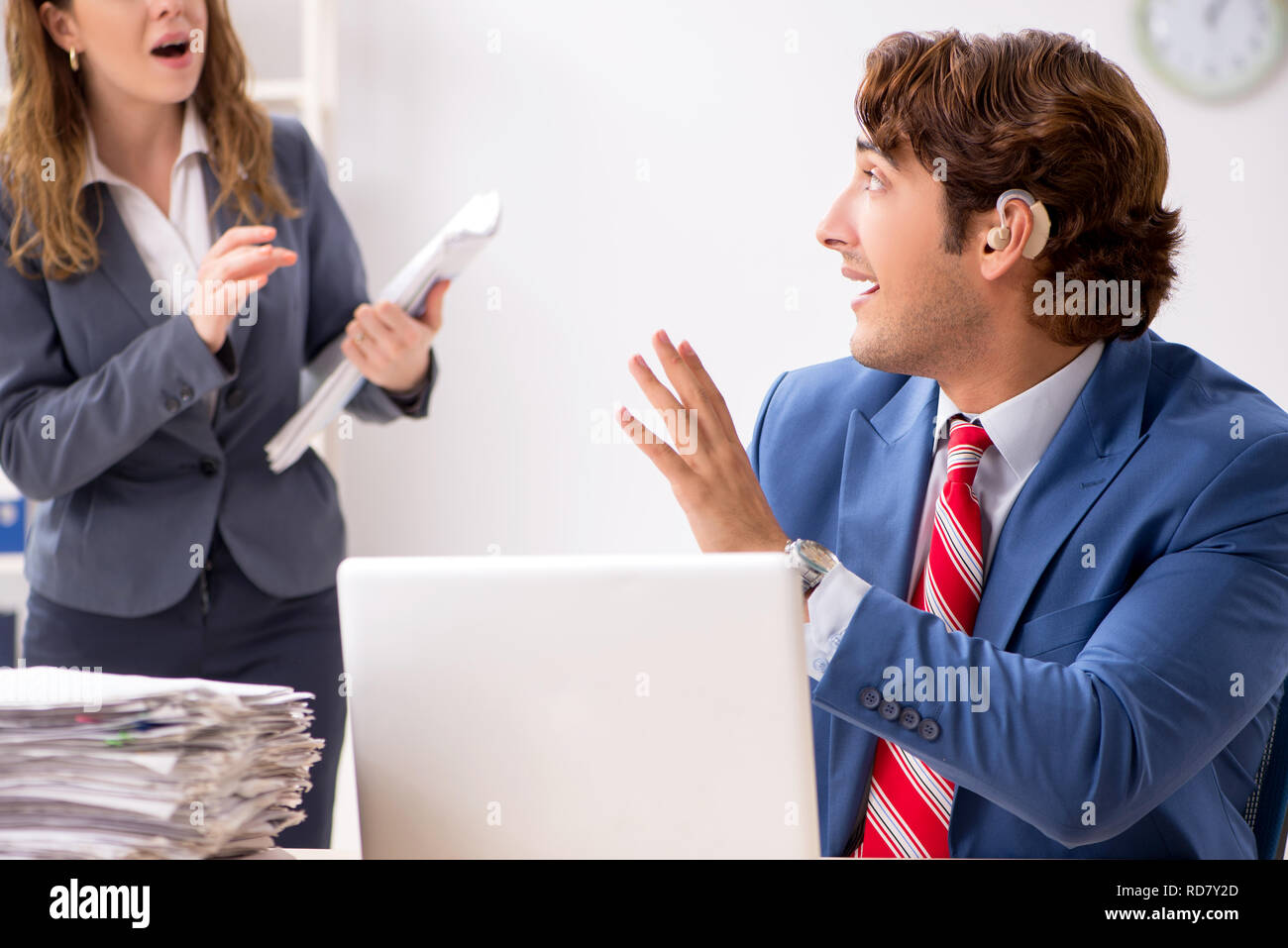 Deaf employee using hearing aid talking to boss Stock Photo - Alamy