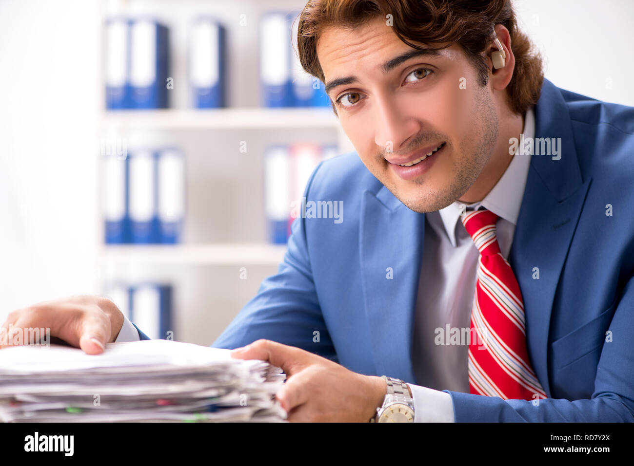 Deaf employee using hearing aid in office Stock Photo - Alamy