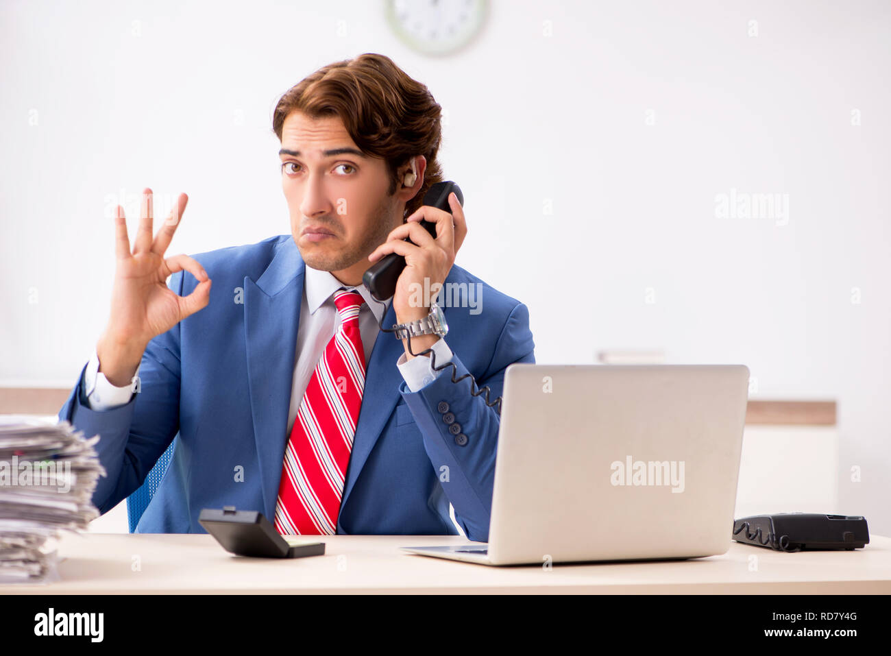 Deaf employee using hearing aid in office Stock Photo - Alamy