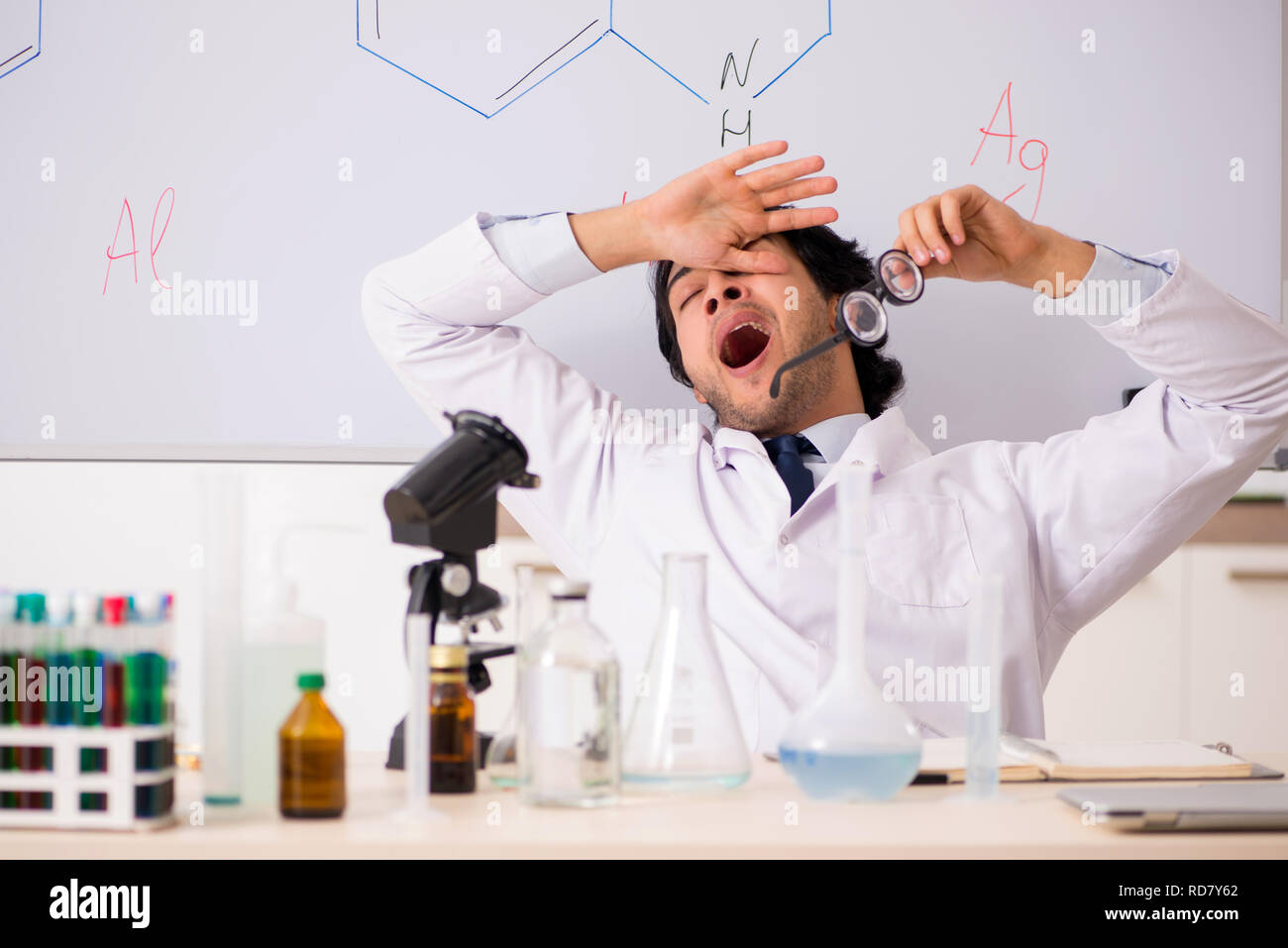 Young funny chemist in front of white board Stock Photo - Alamy