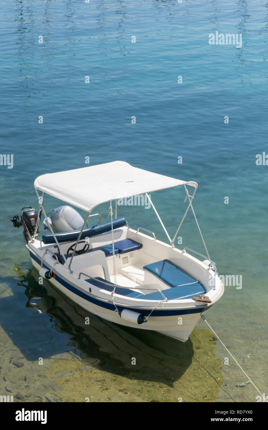 Small white blue motorized boat anchored on the shore Stock Photo - Alamy