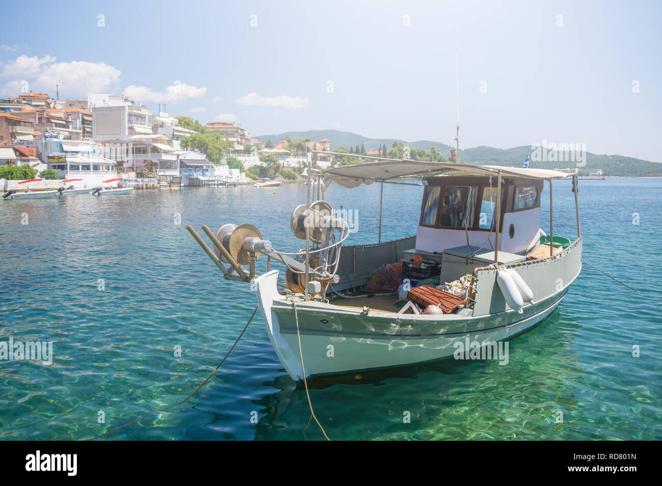 White fishing boat anchored next to the dock in town Stock Photo - Alamy