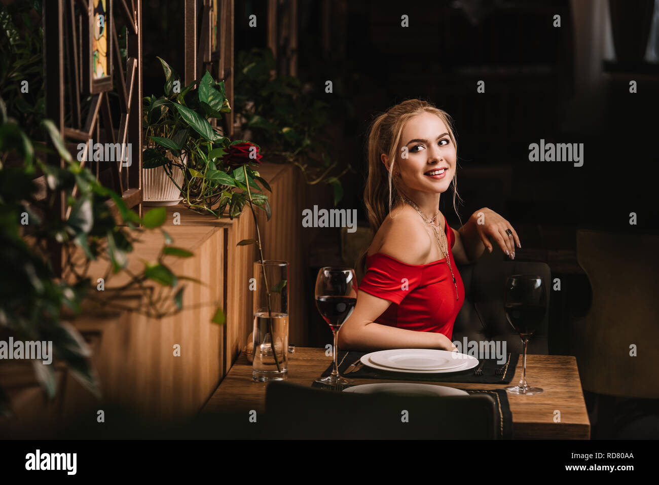 attractive blonde woman waiting in red dress in restaurant Stock Photo ...