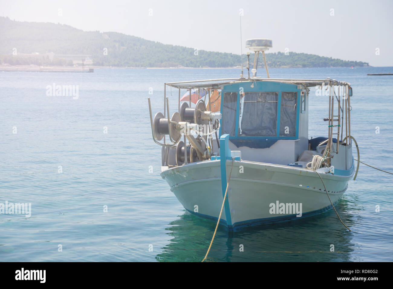 Small white overloaded fishing boat anchored next to the dock Stock ...